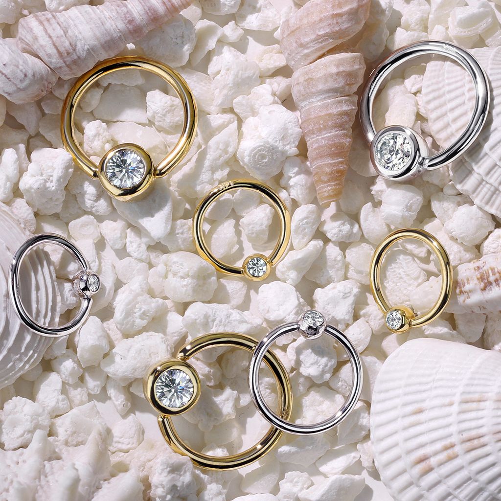 Luxurious 14k gold captive bead ring with a bezel-set stone